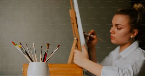 한 여자가 이젤에 그림을 그리고 있다 사진 Unsplash의 직업 이미지