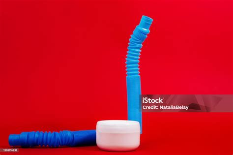 얼굴 데이 크림과 트렌디 한 파란색 튜브의 흰색 항아리는 빨간색 배경에 고립 된 팝업 아름다움의 창조적 인 개념 주름을 부드럽게 합니다 0명에 대한 스톡 사진 및 기타