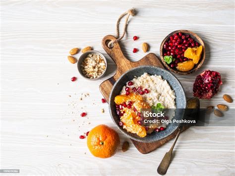 신선한 귤 슬라이스와 석류 씨앗 갈은 아몬드와 민트가 있는 오트밀을 흰색 배경의 파란색 그릇에 담습니다 공간을 복사합니다 맨 위 보기 0명에 대한 스톡 사진 및 기타 이미지