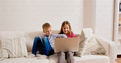 어린 소녀와 소년은 집에서 노트북 컴퓨터로 소파에 앉아 있다 Pc를 사용하여 실내에서 노는 행복한 아이들 사진 Unsplash의 소년 이미지