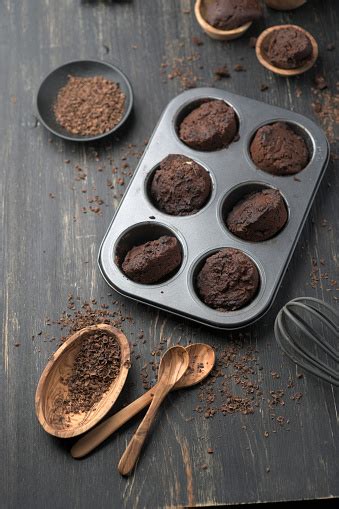 초콜릿 토 핑 Delish와 간단한 디저트와 수 제 초콜릿 머핀 초콜릿 드랍 스와 맛 있는 수 제 머핀 측면에 어두운 배경