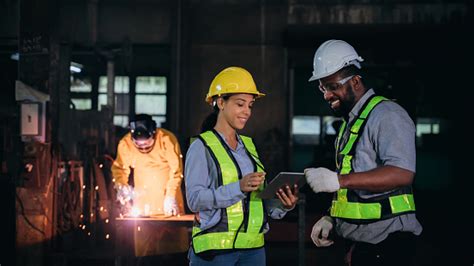 엔지니어가 공장에서 일하고 있습니다 기계의 준비 상태를 수리하고 검사하는 것을 돕는 작업자 기계 기술자가 오작동하는 열차 차고에서 엔진을 유지 관리하고 있습니다 2명에 대한