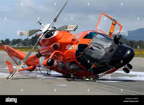 A Us Coast Guard Mh 65 Dolphin Helicopter Lays On Its Side After It