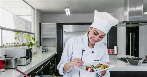 멕시코 라틴 아메리카의 상업용 주방에서 멕시코 초콜릿 사탕을 접시에 담은 요리사 모자를 쓴 젊은 라틴 여성 쇼콜라티에 사진 Unsplash의 과자 장수 이미지