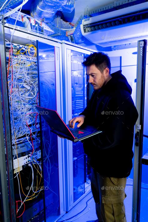 Focused Hacker In Data Center Hacking Software System Vulnerable Cyber Security Server Room