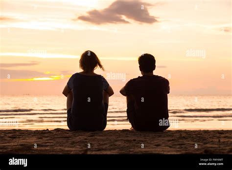 Amici Seduti Insieme Sulla Spiaggia E Guardare Il Tramonto Il Concetto Di Amicizia Foto Stock
