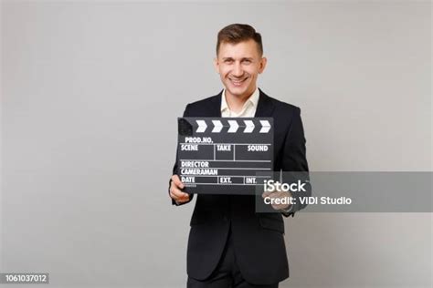 젊은 미소 클래식 블랙 비즈니스 남자 벌 셔츠 지주 고전적인 흑인 영화 Clapperboard 회색 벽 배경에 고립 된 만들기 성과 경력 부 비즈니스 개념입니다 복사 공간을