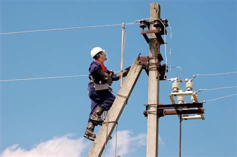 Premium Photo An Electrician Climbs A Pole Of A Grounded Power Line To Replace A Faulty Insulator