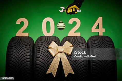 자동차 타이어 새 타이어 나비 리본이 있는 녹색 배경에 고립된 겨울 바퀴 및 렌치를 가진 수리공 손 2024년에 대한 스톡 사진 및 기타 이미지 Istock