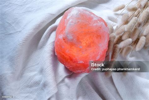 히말라야 소금 램프 분홍색 소금 결정이 있는 램프 텍스트를 위한 빈 공간이 있는 흰색 니트 패브릭에 말린 토끼 꼬리 풀 평면도