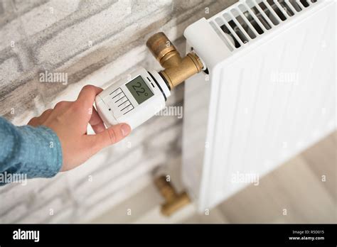 Person Adjusting Temperature On Thermostat Stock Photo Alamy