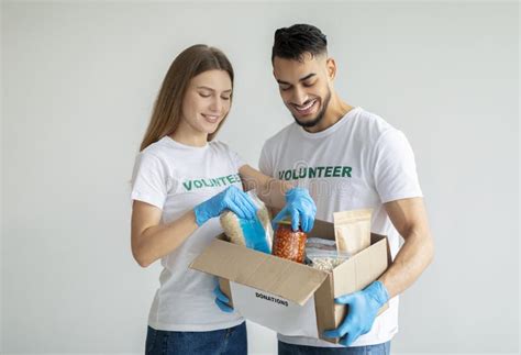 Happy Activist Volunteers Packing Food Donations Putting Cans And Jars