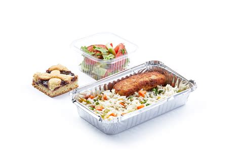 흰색 배경 일회용 플라스틱 및 호일 식기 비행기 음식 스낵 야채를 곁들인 중국식 찐 밥 신선한 야채를 곁들인 생선 커틀릿 건강한 식생활 달콤한 케이크 0명에 대한 스톡 사진