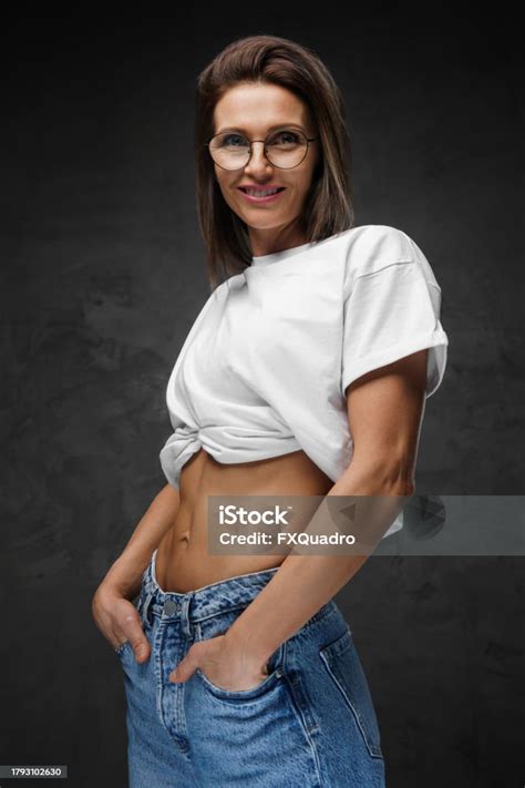 Woman Smiles In Eyewear Lifting Her Croptop To Spotlight A Sculpted