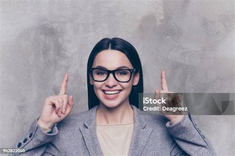 안경에 정장 회색 벽 근처에 서 있는 동안 손가락으로 가리키는 흥분된 쾌활 한 젊은 성공적인 사업가의 초상화 가리키기에 대한 스톡 사진 및 기타 이미지 Istock