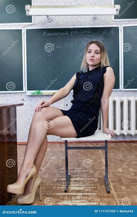 Strict Young Blonde Teacher Sits On A Chair Crossing Her Legs Stock Image Image Of Happy