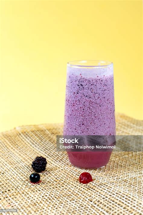 노란색 배경에 신선한 베리 믹스 스무디 또는 밀크 셰이크 블랙 베리 블루 베리 및 라스베리의 안경 텍스트를위한 복사 공간 건강한