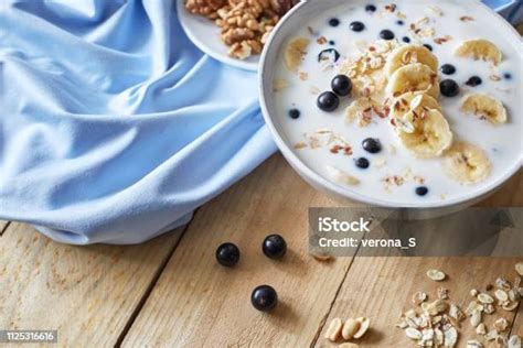 오트밀 Porridgewith 바나나 견과류 건포도 블루베리와 우유 나무 배경에 테이블에 건강 한 아침 식사와 다이어트 음식입니다 0명에 대한 스톡 사진 및 기타 이미지