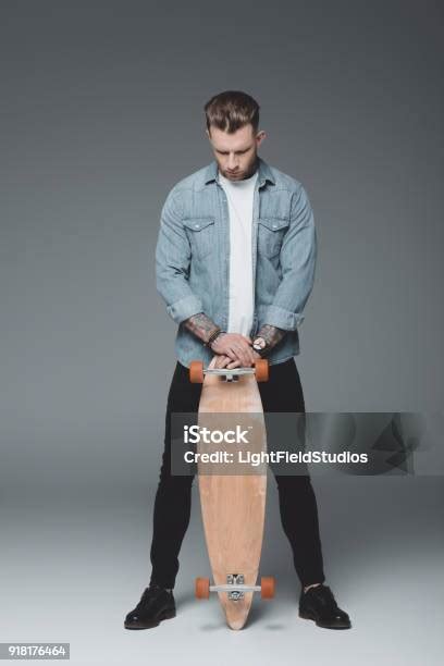 회색에 스케이트 보드와 함께 서 있는 잘생긴 젊은 문신된 남자의 전체 보기 남자에 대한 스톡 사진 및 기타 이미지 남자 문신 전신 Istock
