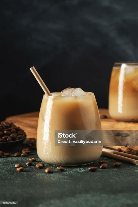 크림이 쏟아진 키가 큰 유리잔에 담긴 아이스 커피 어두운 콘크리트 테이블 위에 얼음 조각과 콩 0명에 대한 스톡 사진 및 기타 이미지 Istock