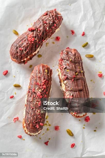 딸기와 피스타치오를 곁들인 달콤하고 초콜릿 에클레어 가득 찬에 대한 스톡 사진 및 기타 이미지 가득 찬 갈색 거품 내기 Istock