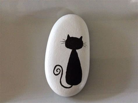 A Painted Rock With A Black Cat On It