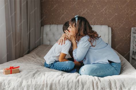 Maman Et Son Fils Sont Assis Sur Le Lit Sembrassent Et Samusent