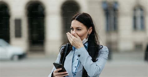 알레르기 또는 계절성 독감으로 고통받는 우아한 비즈니스 여성은 도시 공원에 서서 얼굴 조직에서 기침과 재채기를 합니다 사진 Unsplash의 사람 이미지