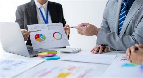 재무 그래프 데이터 및 마케팅 계획을 설명하는 비즈니스 담당자 회의 회의에서 비즈니스 사람들의 그룹은 비즈니스 투자 및 마케팅의 상태를 평가합니다 Future