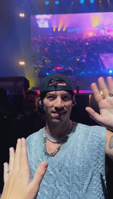 A Man With His Hands In The Air At A Concert