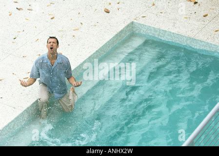 Man Splashing In Pool Fully Clothed Smiling At Camera High Angle View Stock Photo Alamy