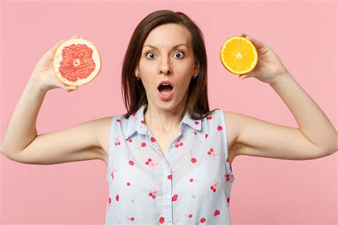 신선한 익은 자 몽 오렌지 과일 분홍색 파스텔 벽 배경에 고립의 Halfs를 들고 입 오픈을 유지 젊은 여자 충격 사람들은 생생한 라이프 스타일 휴식 휴가 개념입니다 복사