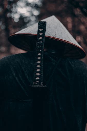 고독한 사무라이가 고요한 자연 속에서 힘 용기 명예를 상징하는 믿음직한 장검을 손에 단단히 들고 어두운 숲 속을 헤매고 있습니다 숲에서 카타나를 가진 사무라이 Bushido