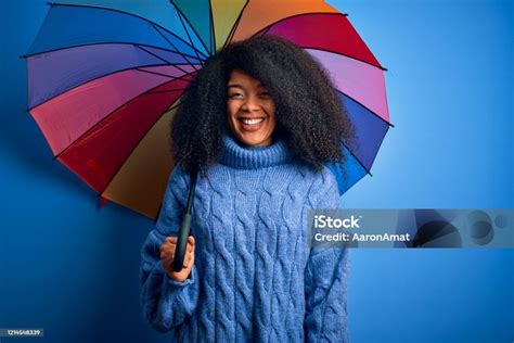 행복한 얼굴 서서 치아를 보여주는 자신감 미소와 함께 미소와 겨울 날씨 비에 대한 화려한 우산 아래 아프리카 계 미국인 여성 건강한 생활방식에 대한 스톡 사진 및 기타