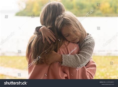Two Sisters Hugging Sadly
