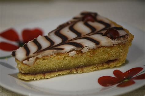 꽃 패턴의 접시에 맛 있는 집에서 만든된 Bakewell 타트 또는 잼으로 케이크와 초콜릿 토 핑과 흰색 장식의 슬라이스 조각 가까이의 음식 사진 제공 0명에 대한 스톡