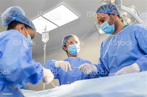 운영 극장에서 직장에서 다민족 외과 의사의 팀의 초상화 그들의 작업 도중 수술 테이블에 환자를 둘러싼 몇몇 닥터 수술실에서 일하는 팀 외과 의사 간호사에 대한 스톡 사진 및
