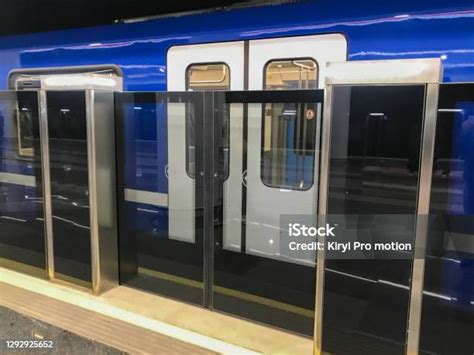 보안이 강화된 지하철 새로운 지하철 역 이중 보안 기차에 들어가기 전에 자동 문 길에 유리 문이 있는 파란색 현대 열차가 도착했습니다 탑승 승객 스크린 도어에 대한 스톡