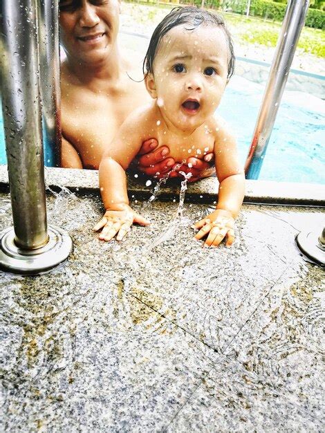 Premium Photo Shirtless Father Carrying Son In Swimming Pool