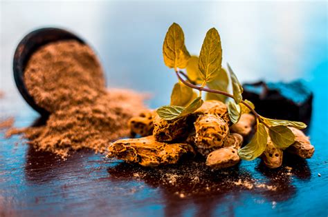 원시 유기농 경화 또는 악마의 똥 나무 표면에 일부 말린 생강과 일부 민트 잎과 함께 진흙 그릇에 거대한 회향의 분말과 함께 보기 또는 샷을 닫습니다 0명에 대한 스톡 사진