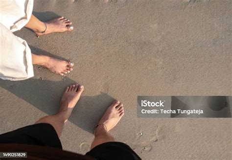 맨발로 연인 커플 여자와 남자가 저녁 일몰에 따뜻한 햇살을 받으며 깨끗한 모래 해변에 서 있다 허니문 여름 여행 레저 목적지 휴가 컨셉 발에 대한 스톡 사진 및 기타 이미지