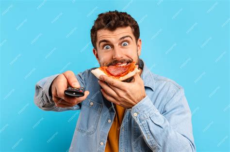 Premium Photo Funny Hungry Millennial Man Eating Pizza And Watching