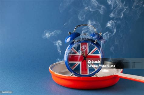 파란색 배경에 연기가 나는 팬에 영국 국기가 있는 알람 시계 변화를 위한 개념 시간 공간을 복사합니다 개념에 대한 스톡 사진 및 기타 이미지 Istock
