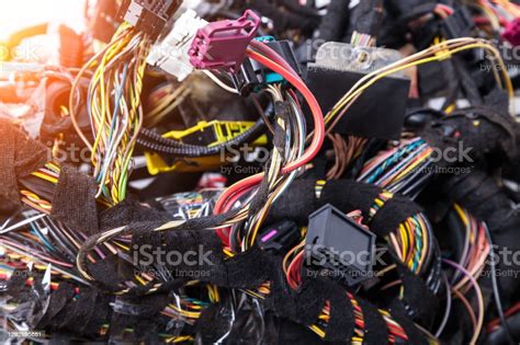 자동차 서비스의 엔지니어 나 정비사가 네트워크 수리 중에 절연 테이프로 재감된 자동차 노드에 흰색 회색과 파란색 색상의 커넥터가있는 다색 전기 와이어 케이블에 대한 스톡