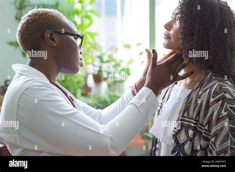 A Black Girl Doctor Examines A Mexican Patient In A Doctors Office