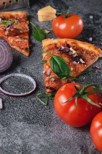 토마토 치즈 양파 허브를 곁들인 전통 이탈리아 페퍼로니 피자를 어두운 슬레이트 테이블에 슬라이스합니다 레스토랑에 대한 스톡 사진 및 기타 이미지 Istock