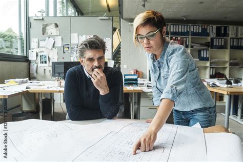 Male And Female Architects Discussing Ground Plan In Office Stock Photo Adobe Stock