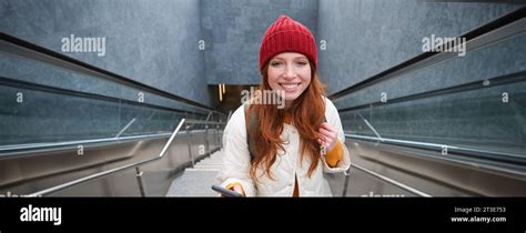 Outdoor Shot Of Young Woman Plans Route Follows Map On Smartphone App