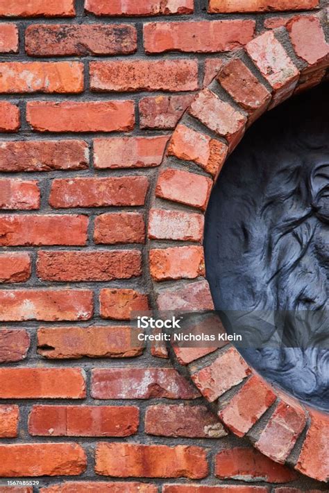 붉은 벽돌 벽의 수직 오른쪽에 물결 모양의 사자 갈기의 검은색 모티브로 반원이 열립니다 0명에 대한 스톡 사진 및 기타 이미지 0명 갈기 미국 Istock
