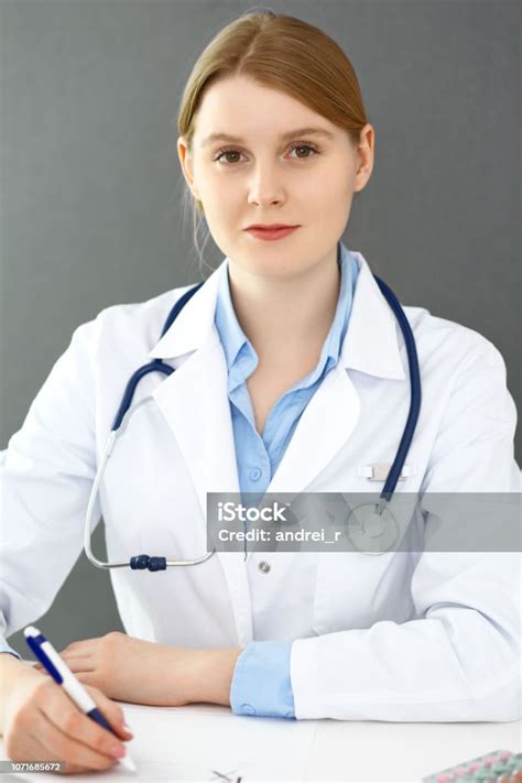 의사 여자 진료소 또는 병원에 창문 가까이 앉아있는 동안 처방전 또는 의료 기록 양식을 작성 의학 및 건강 관리 개념입니다 직장에서 의사 건강 진단에 대한 스톡 사진 및